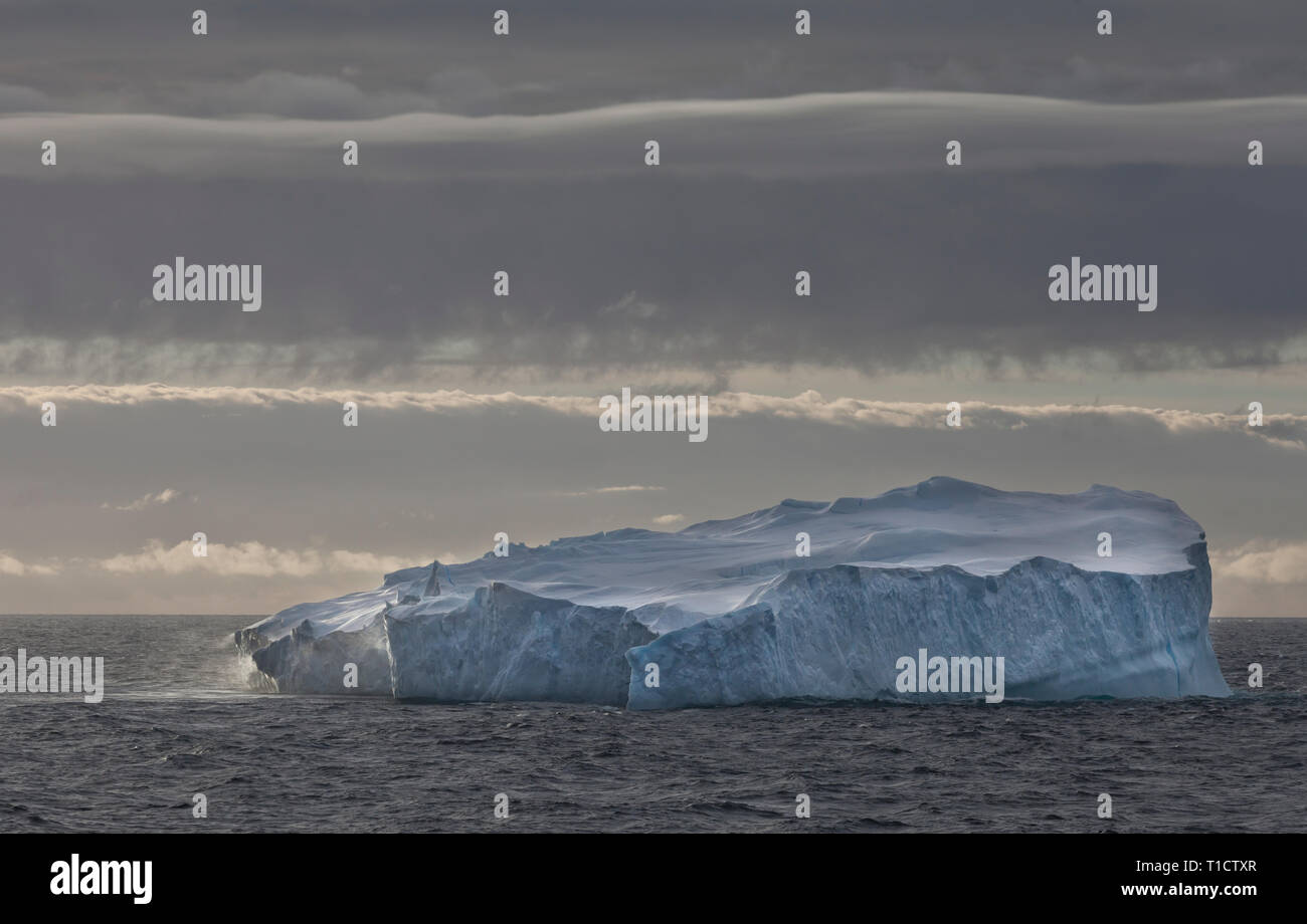 Iceberg with dark clouds Stock Photo - Alamy