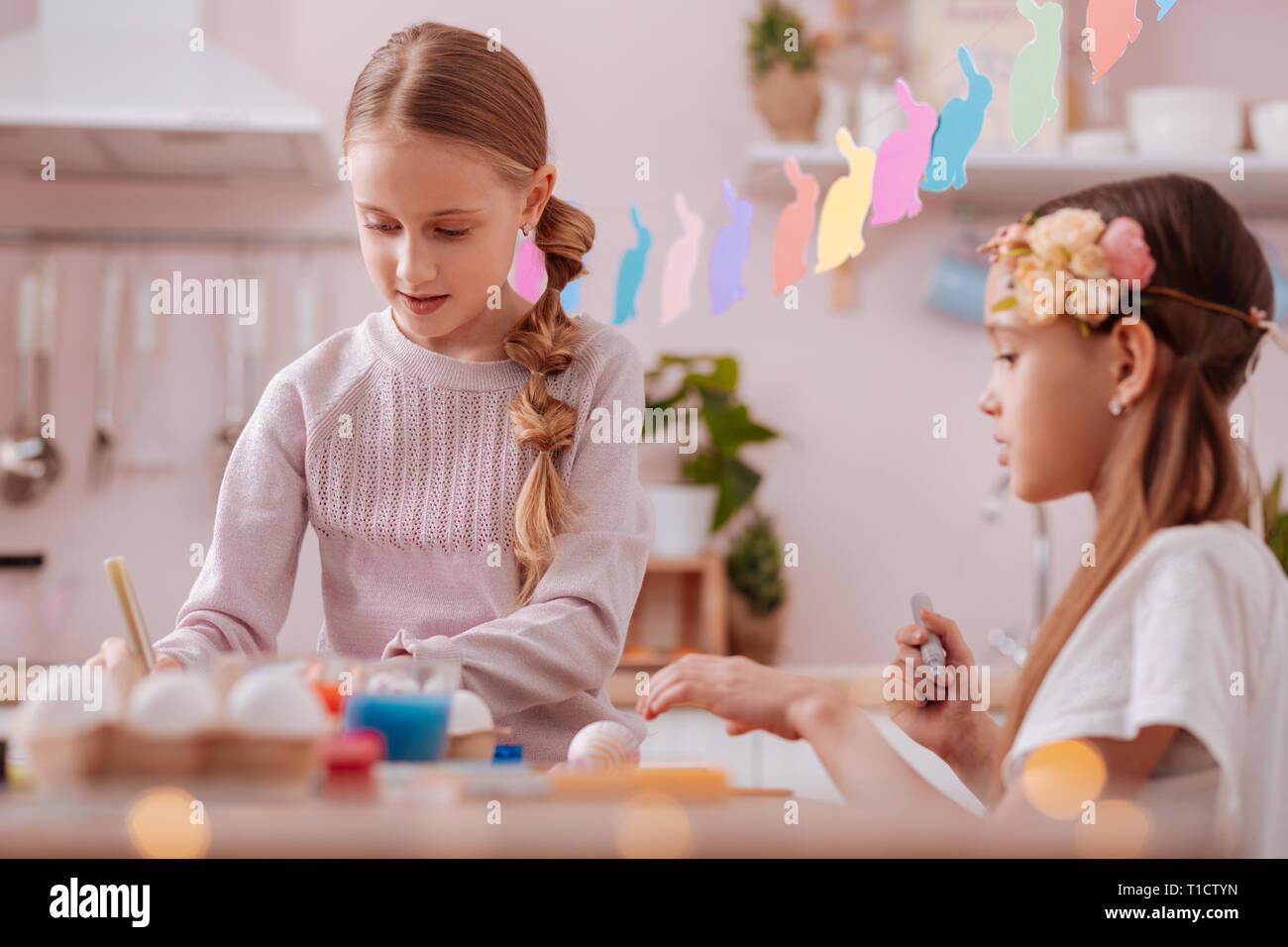 Attentive longhaired girl following example of her friend Stock Photo ...