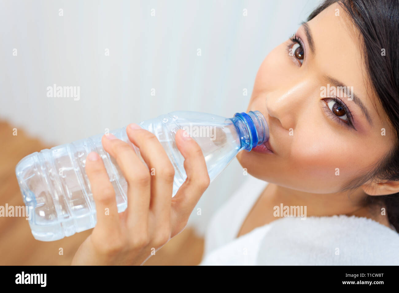 Beautiful female Chinese Asian girl or young woman drinking bottle of ...