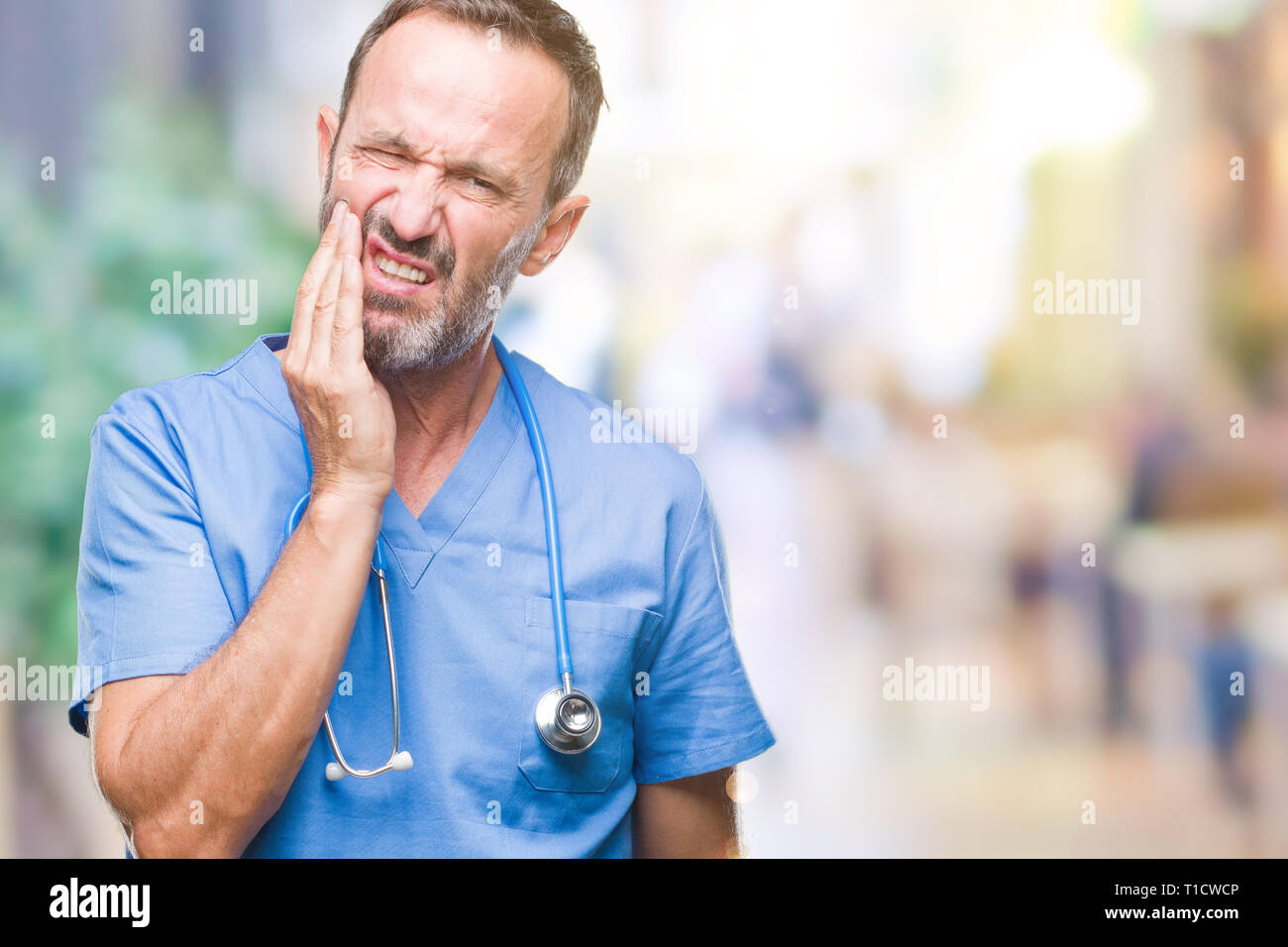Middle age hoary senior doctor man wearing medical uniform over ...