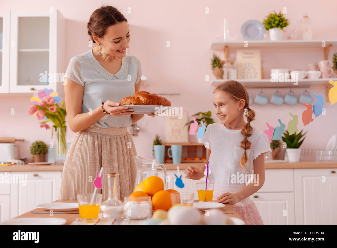 Cute young woman looking at her pretty daughter Stock Photo - Alamy