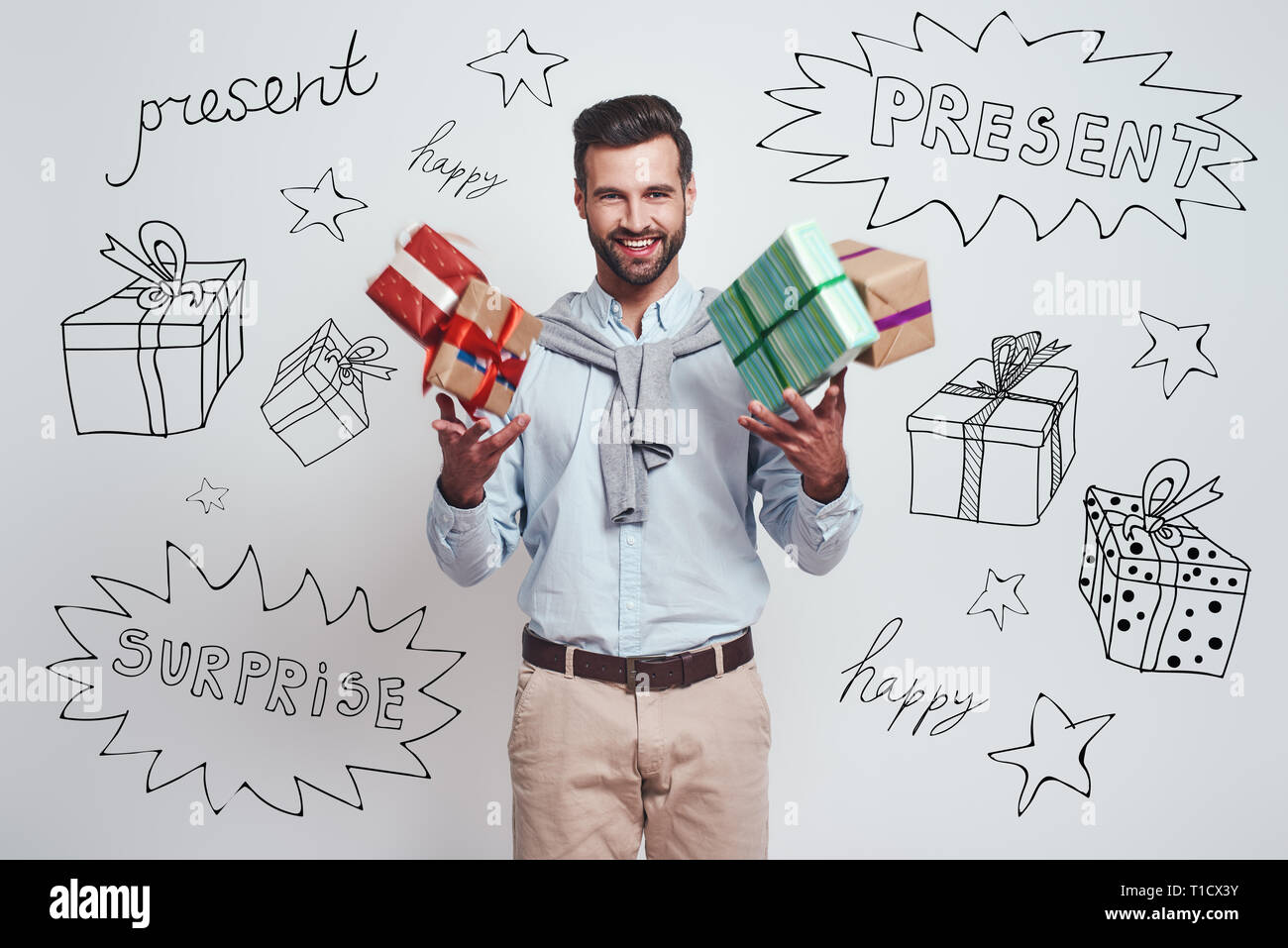Gifts boom! Cheerful young man is holding gifts and feeling so happy ...