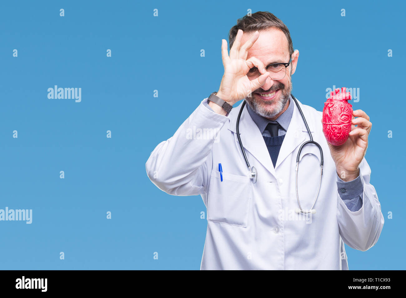Middle age senior hoary cardiologist doctor man holding heart over ...
