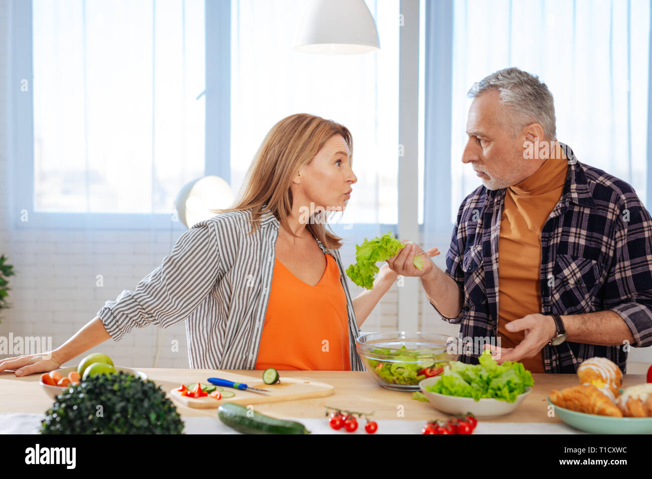 Emotional couple having argument while cooking salad for lunch Stock ...