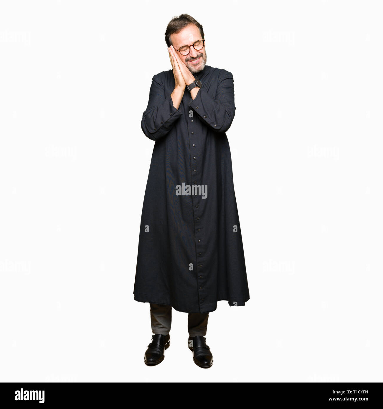 Middle age priest man wearing catholic robe sleeping tired dreaming and ...