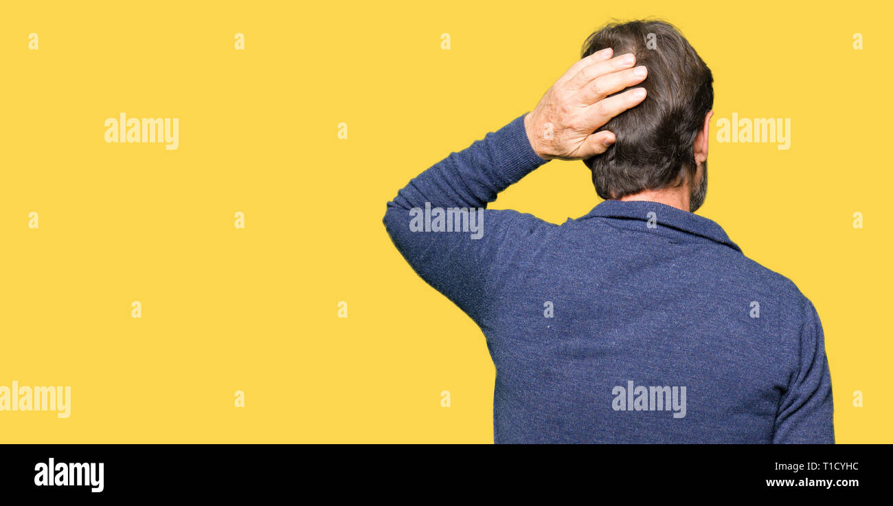 Middle age handsome man wearing a sweater Backwards thinking about ...