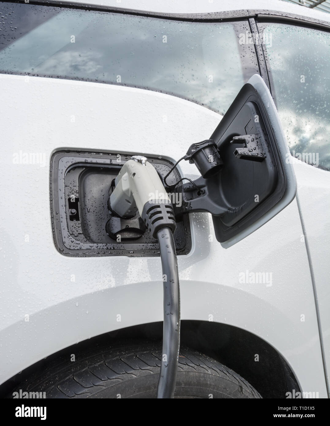 Electric vehicle with the power plug connected to the car Stock Photo ...