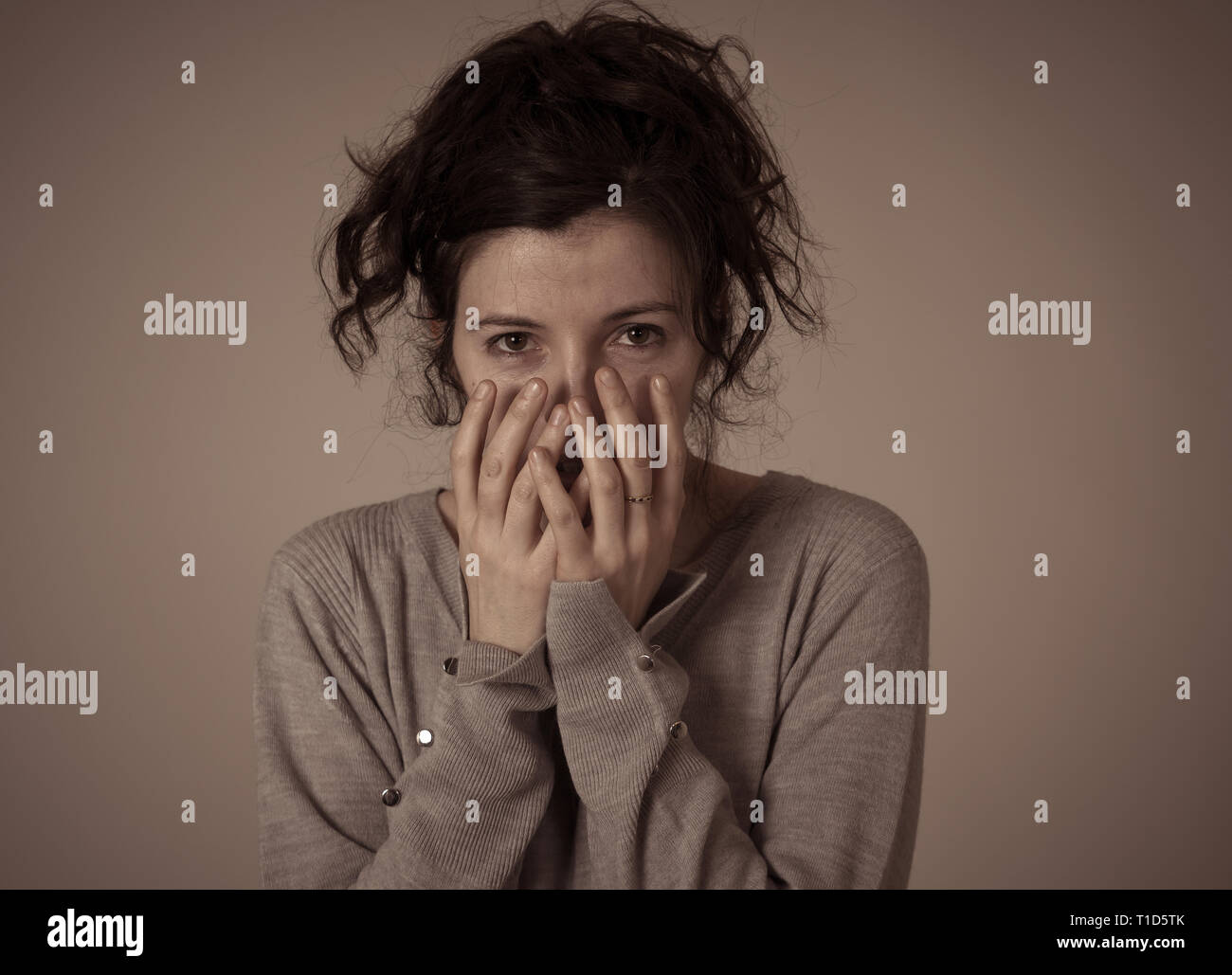 Close up of a young scared and frightened woman, covering herself from ...