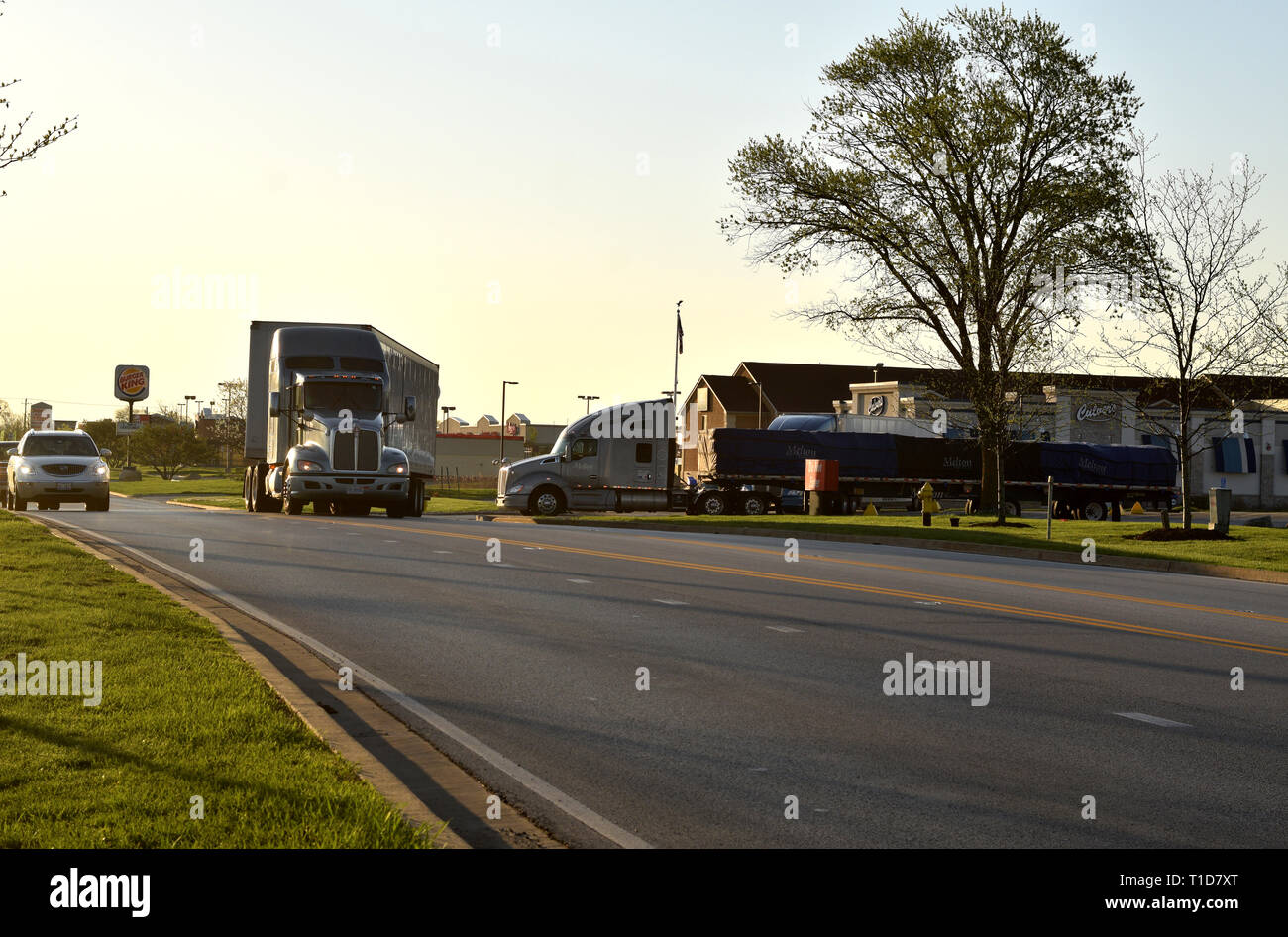 Two Semi-trucks (18 wheelers) leaving a truck stop entering a road ...