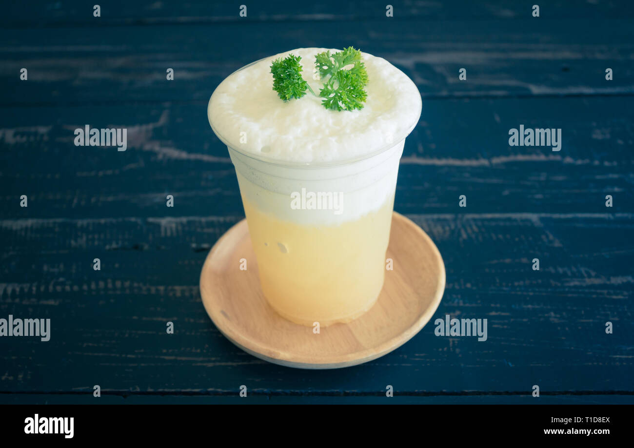 Pineapple juice with Milk froth and Parsley on Black Wood Table ...