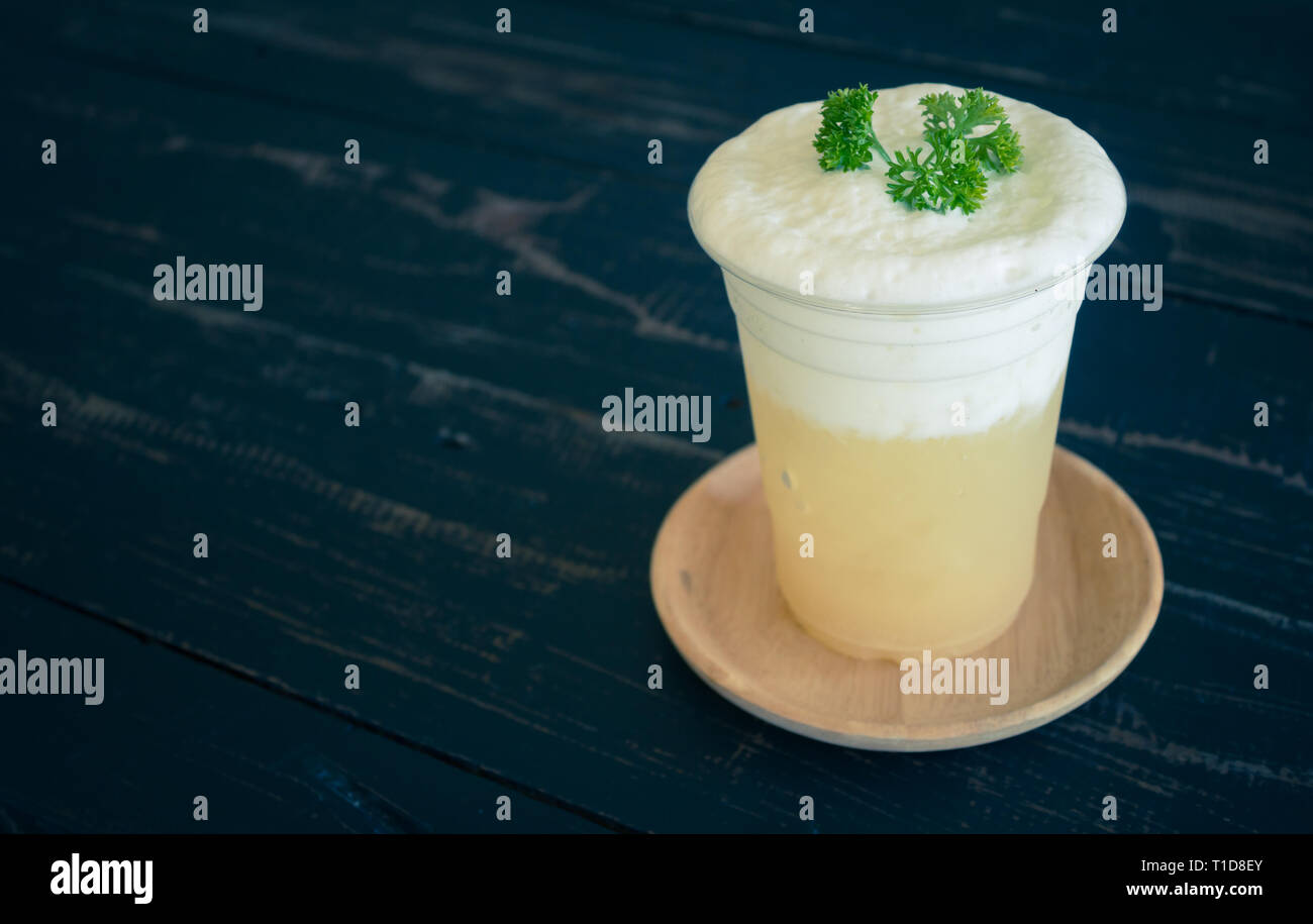 Pineapple juice with Milk froth and Parsley on Black Wood Table ...