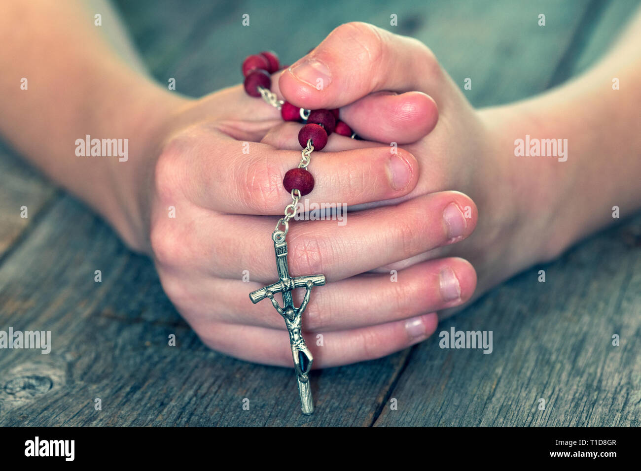 Childs hands holding catholic rosary. Child praying. Shallow DOF Stock ...