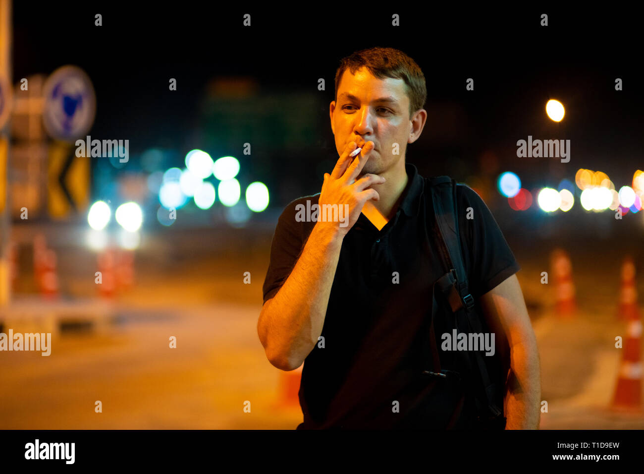 man smoking a cigarette on the street at night Stock Photo - Alamy