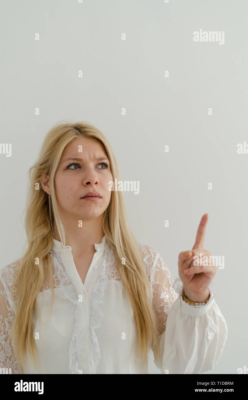 Emotional unhappy young glamorous female dressed in lace shirt frowning ...