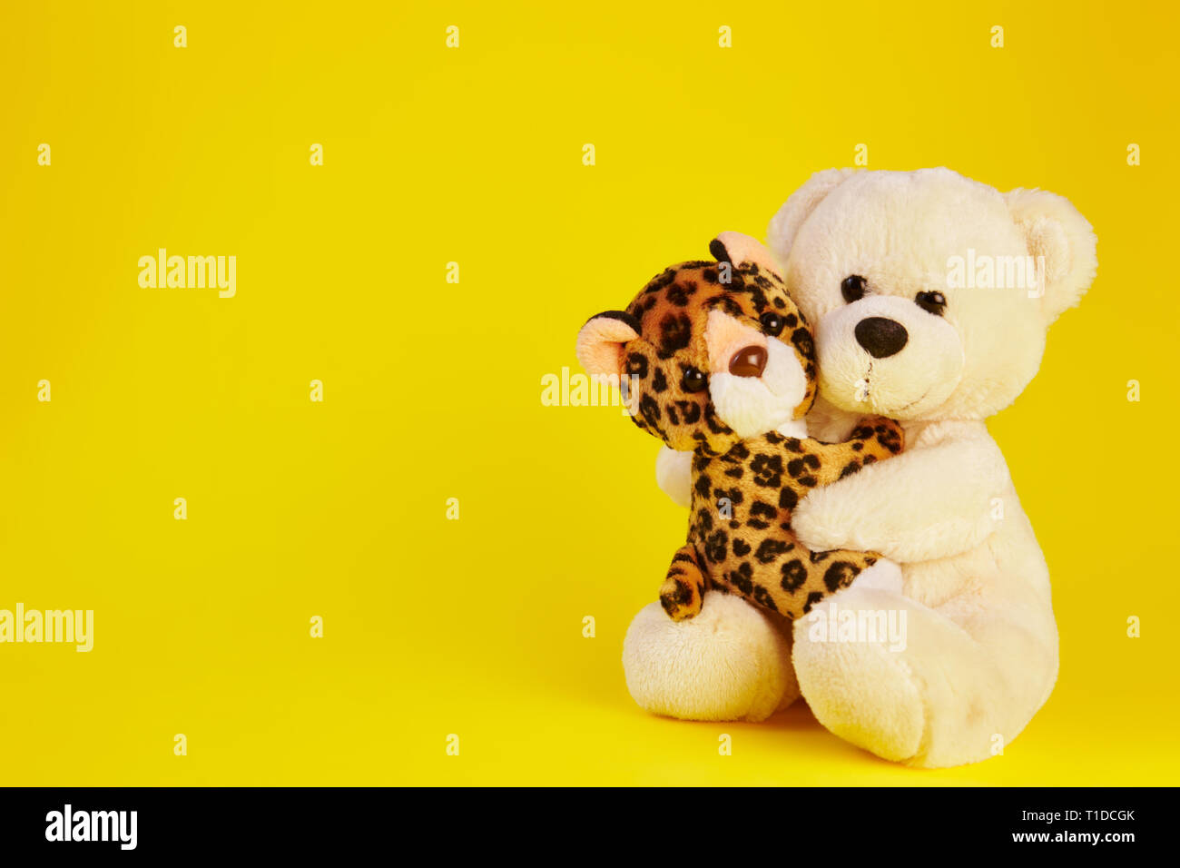 toy bear and a toy leopard with a yellow background Stock Photo - Alamy