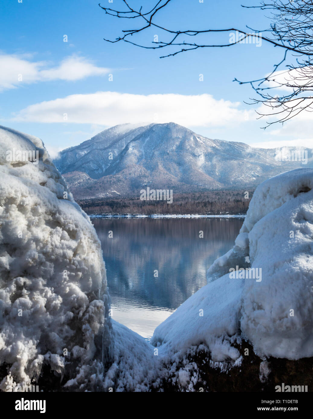 Snow on rocks and ice forming below. The distant mountain peak is ...