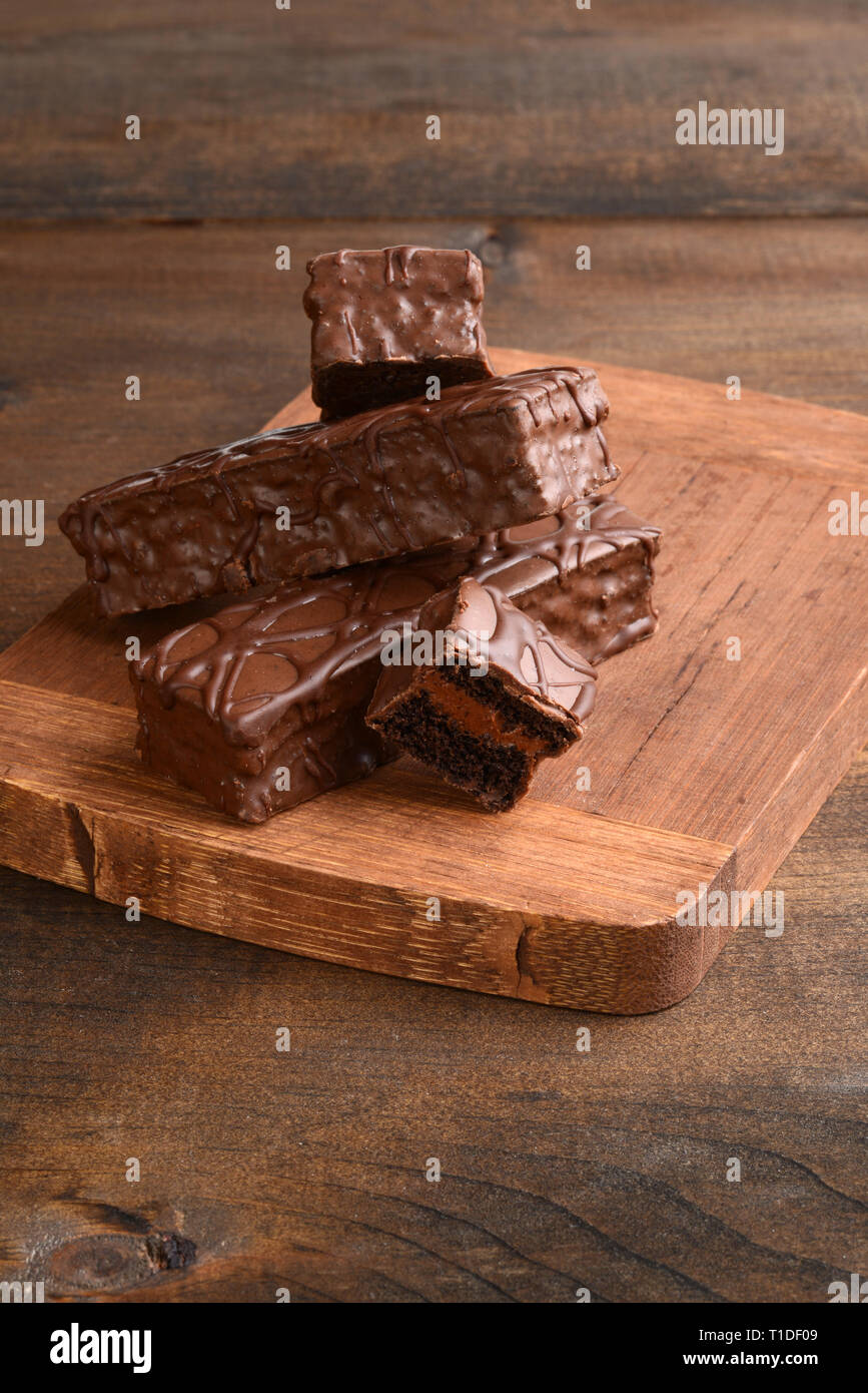 pile of chocolate cream filled bar cakes on cutting board Stock Photo ...