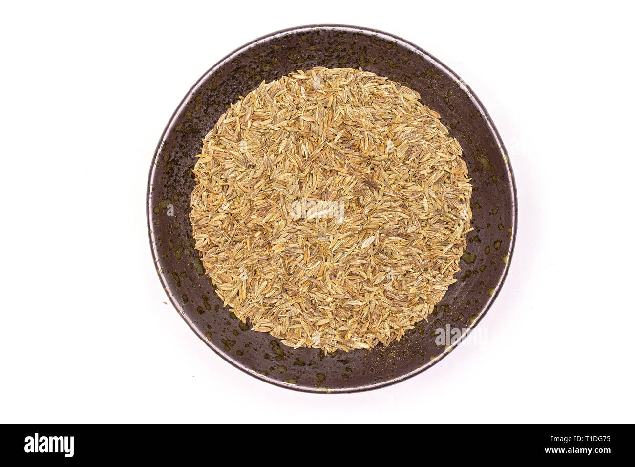 Lot of whole roman caraway seeds in a grey ceramic bowl flatlay ...