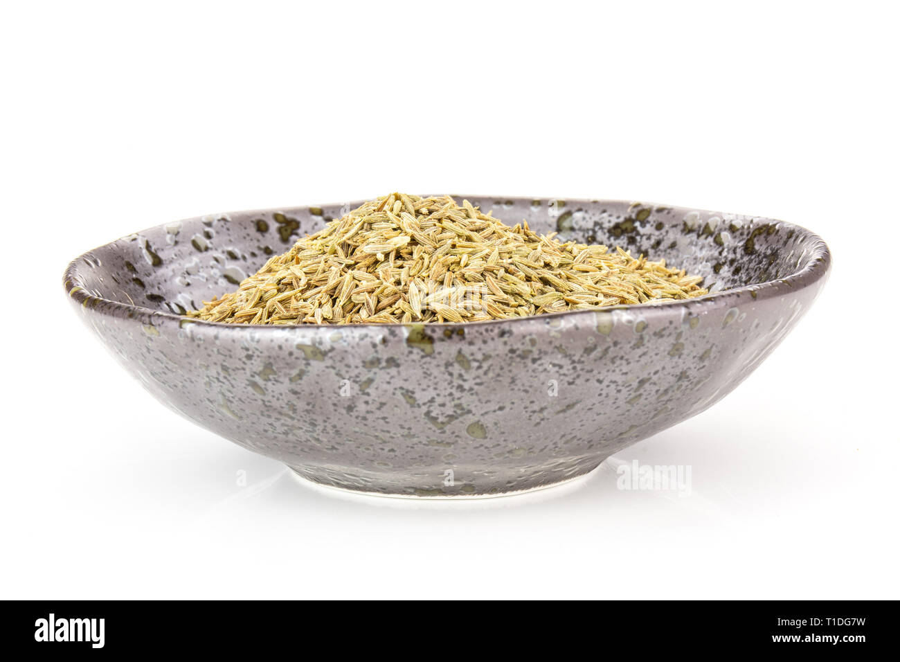 Lot of whole roman caraway seeds closeup in a grey ceramic bowl ...