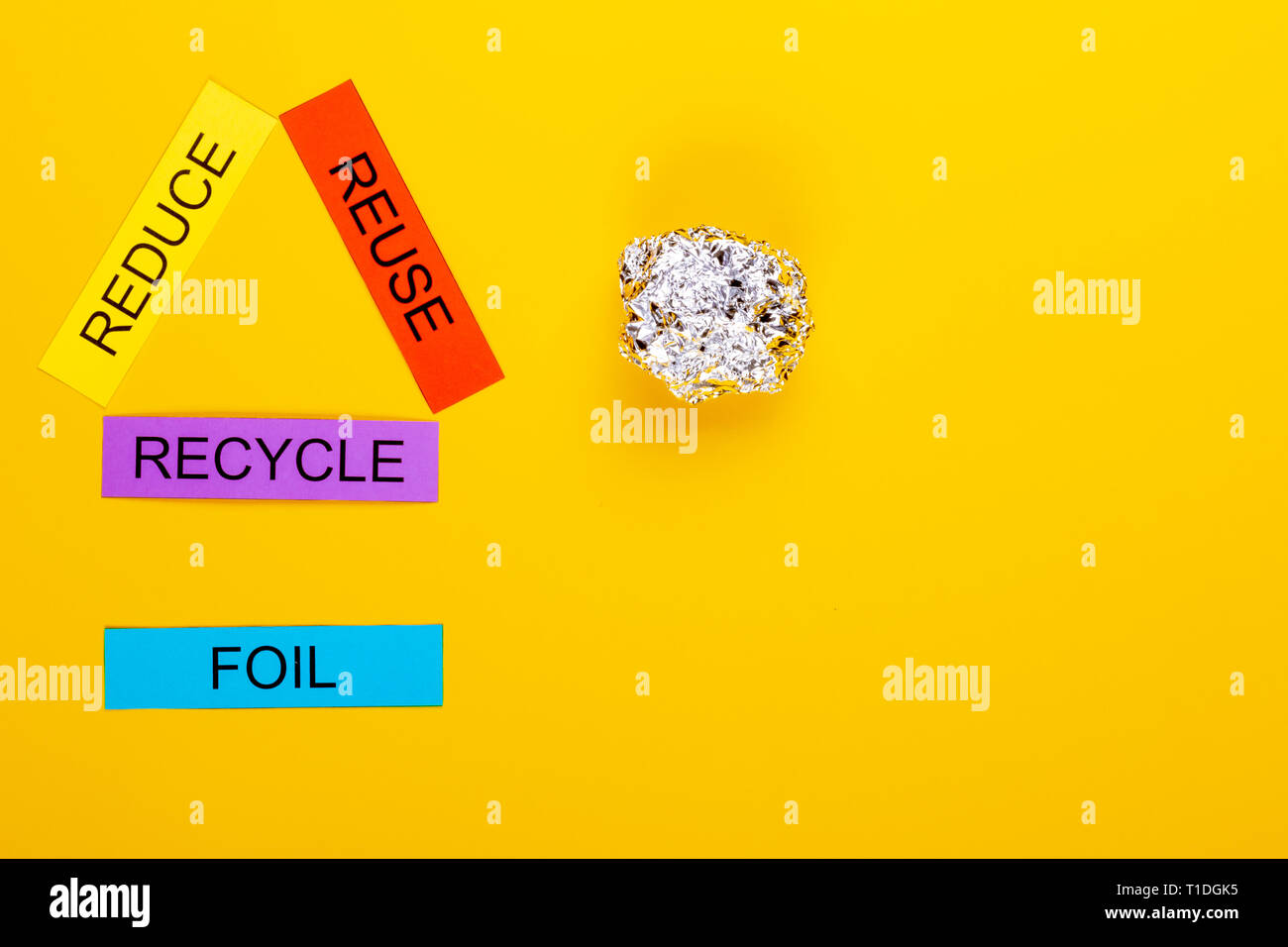Recycling concept showing reduce, reuse & recycle with foil on a yellow ...