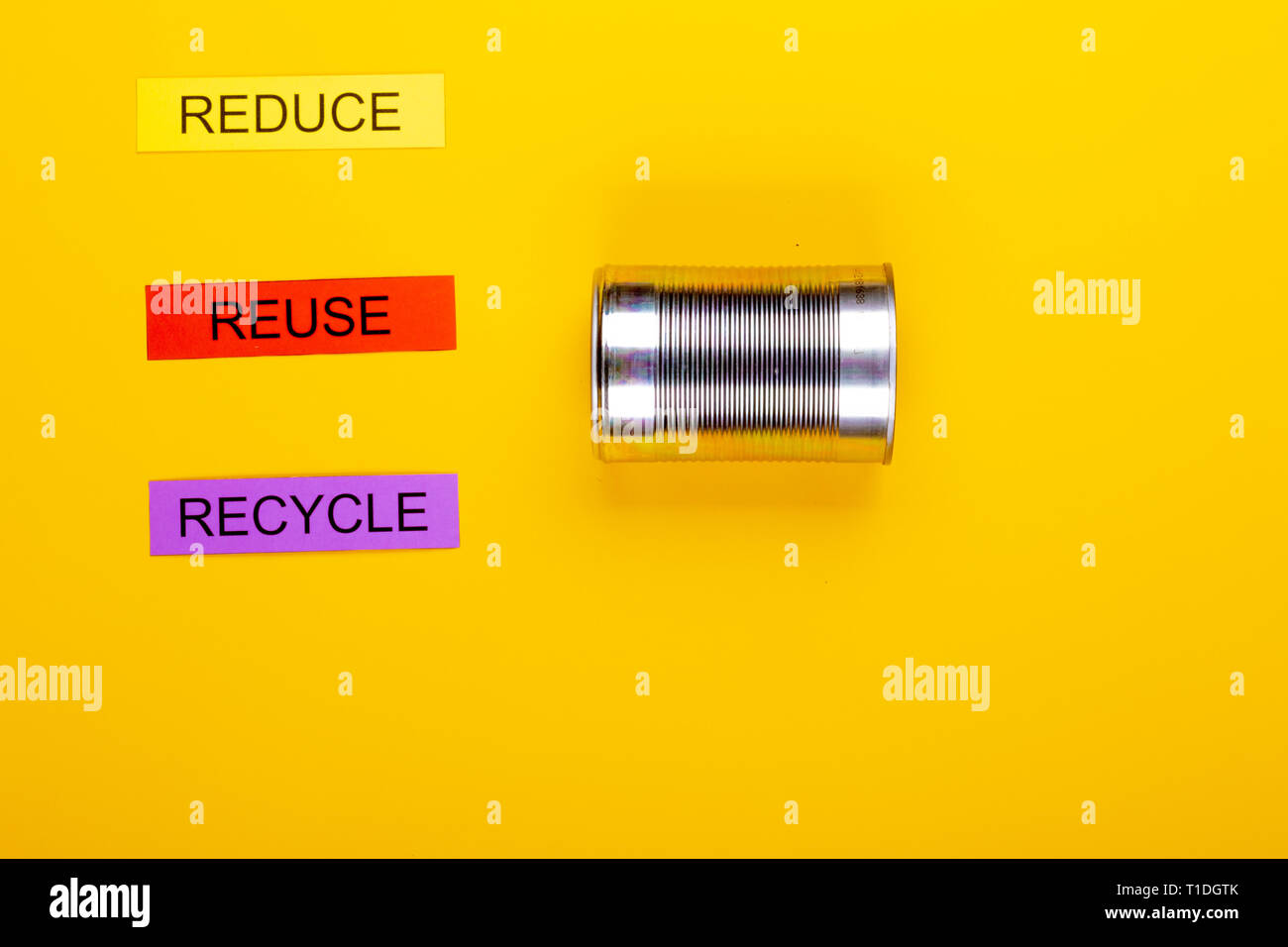Recycling concept showing reduce, reuse, recycle & cans on a yellow ...
