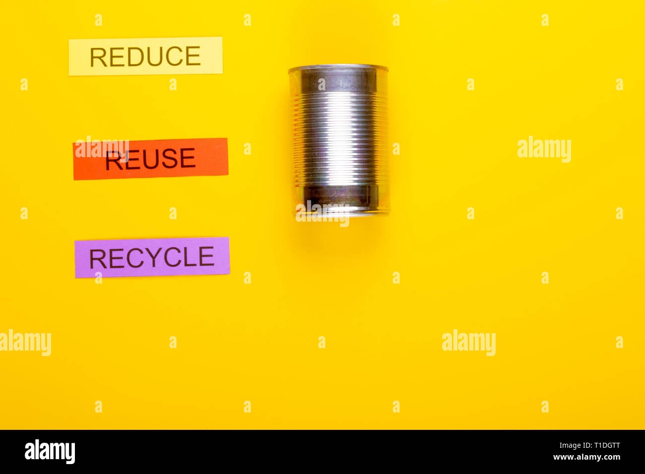 Recycling concept showing reduce, reuse, recycle & cans on a yellow ...