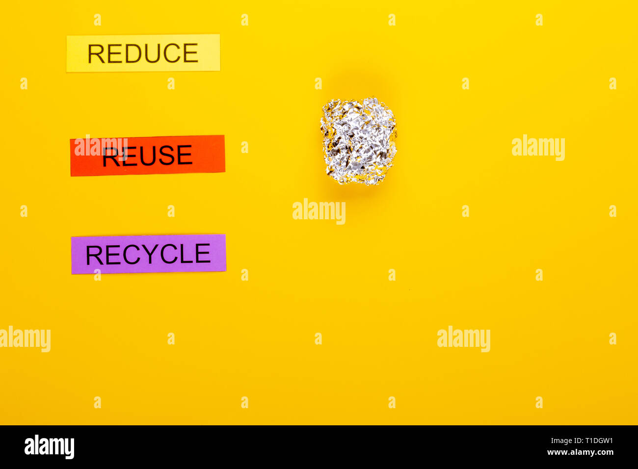 Recycling concept showing reduce, reuse, recycle & foil on a yellow ...