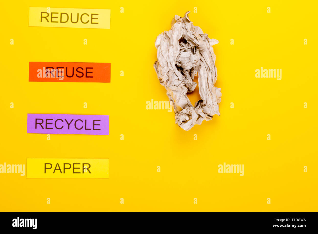 Recycling concept showing reduce, reuse, recycle & paper on a yellow ...