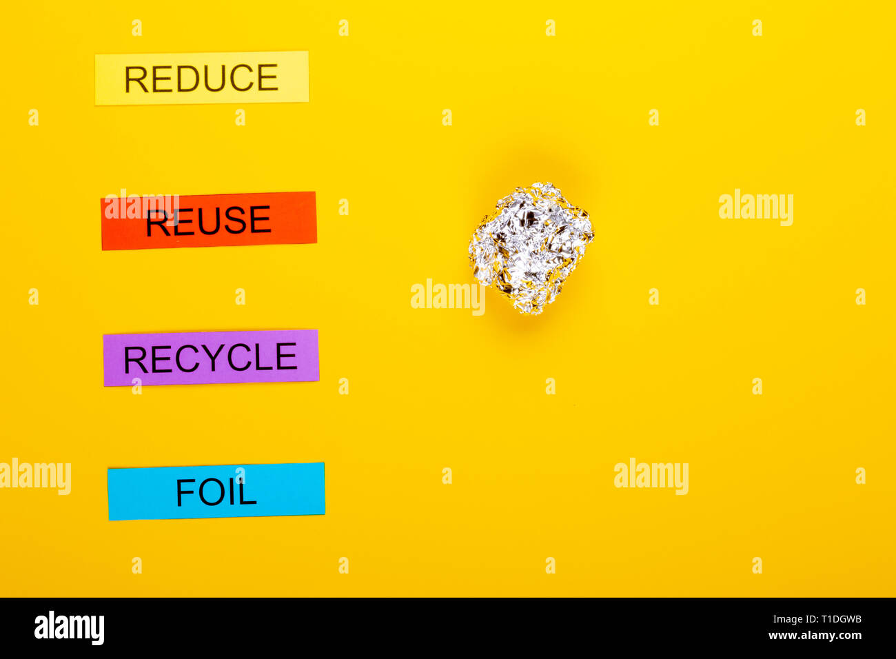 Recycling concept showing reduce, reuse, recycle & foil on a yellow ...