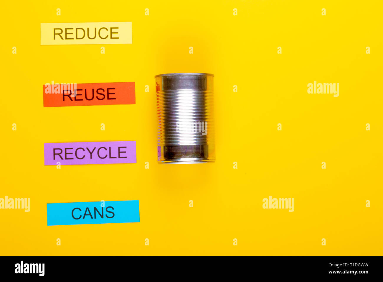Recycling concept showing reduce, reuse, recycle & cans on a yellow ...