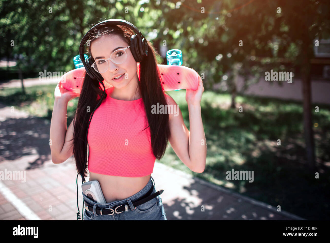 Attractive woman in pink shirt is posing. She is looking straight at ...