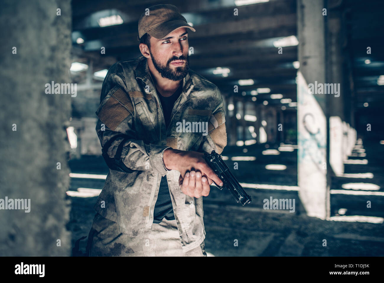Calm fighter wears military uniform. He is standing besides column and ...
