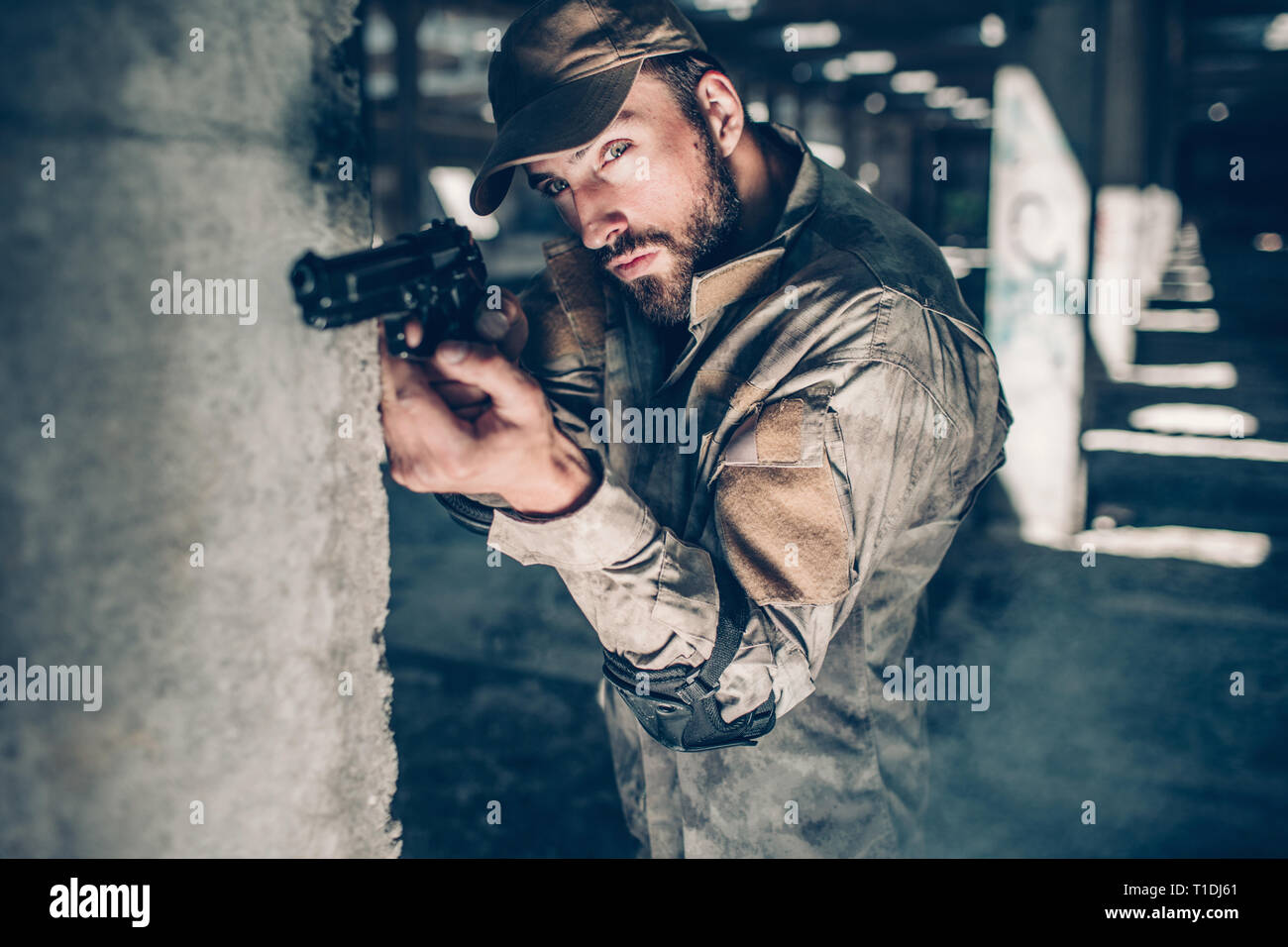 Concentrated and serious man is looking through lens straight forward ...