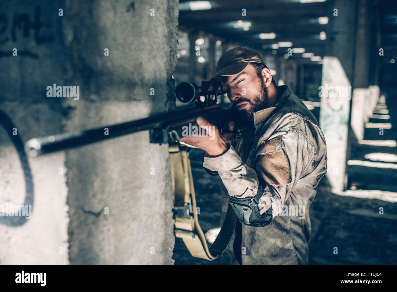 Calm and quiet adult is looking through lens. He is taking aim. Guy is ...