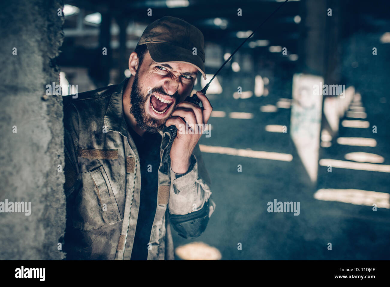 Man from army is holding portable radio close to his face and talking ...