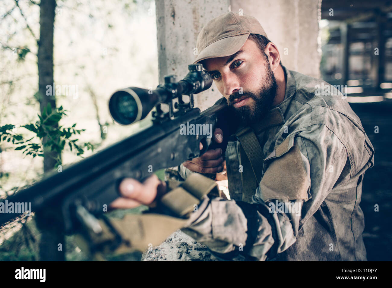 Serious and courage warrior is standing near open exit from hangar and ...