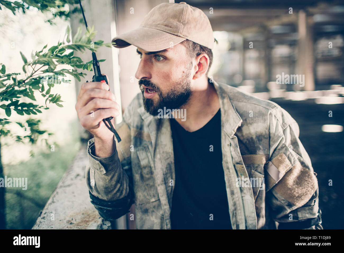 Careful hireling is talking to portable radio by holding it in right ...