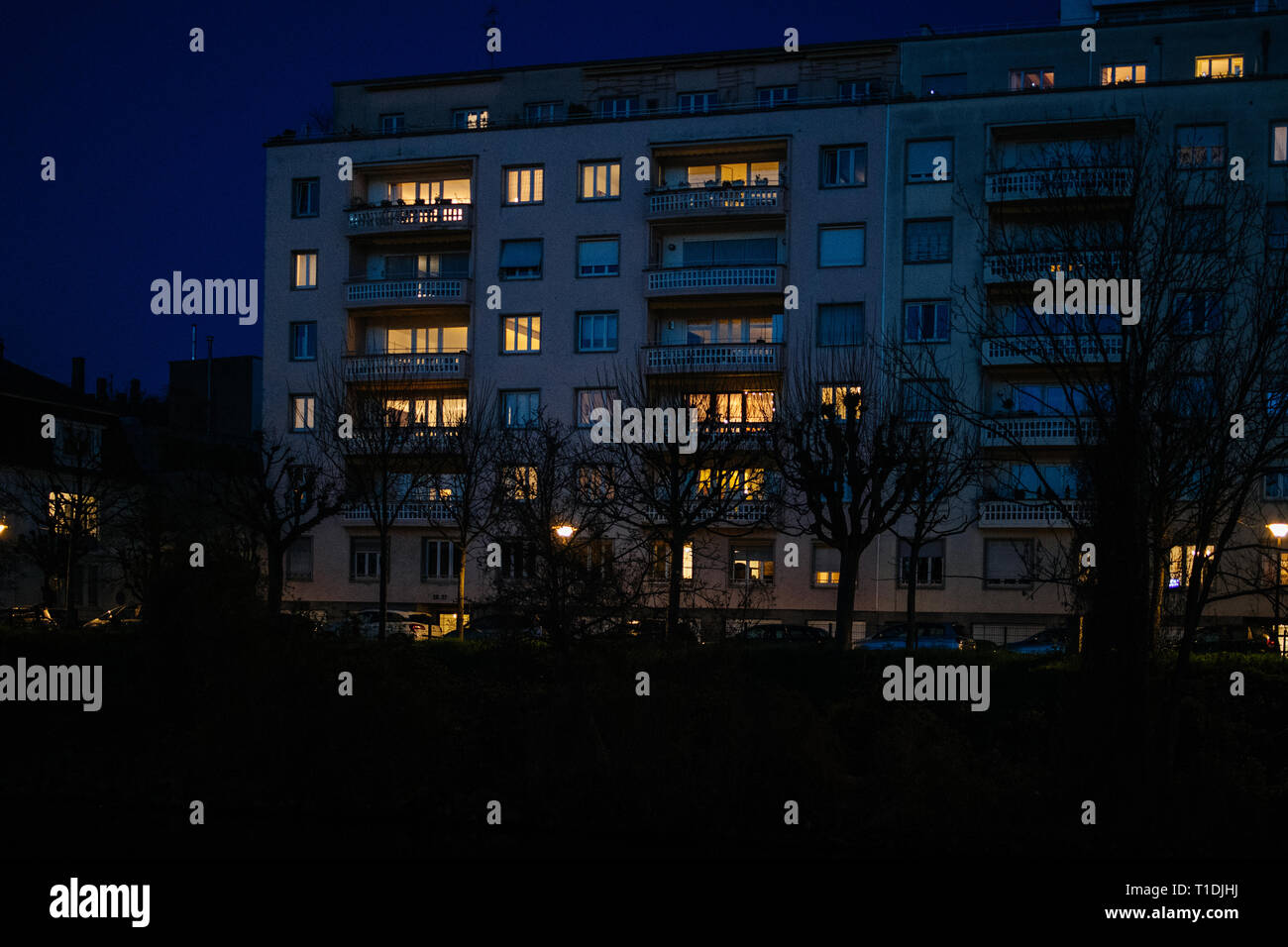 Big apartment building at dusk with illuminated windows home warm ...