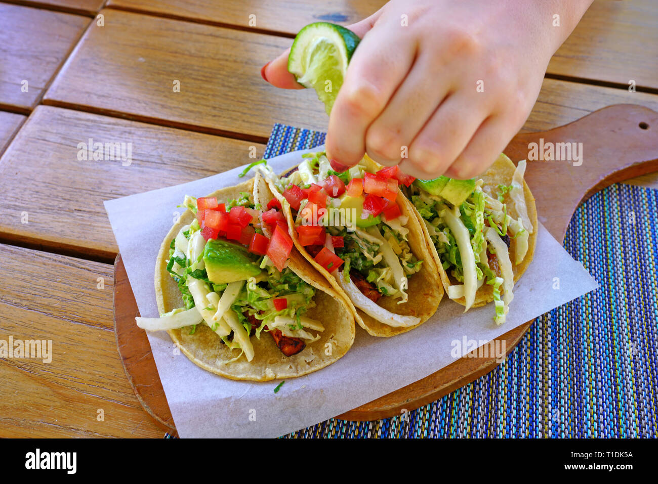 Eating three fish tacos with fresh salsa and avocado Stock Photo - Alamy