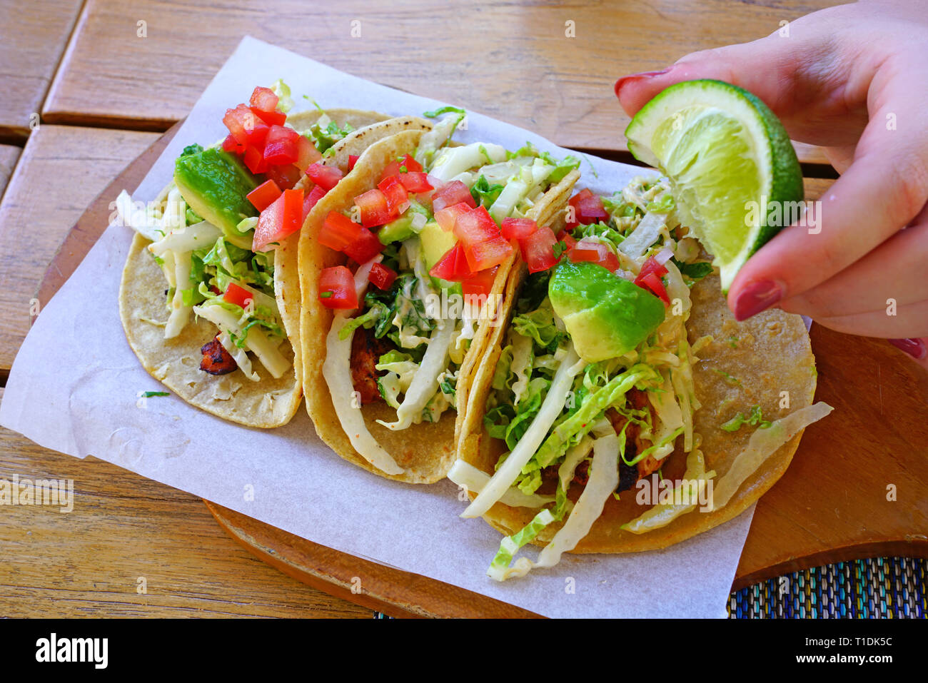 Eating three fish tacos with fresh salsa and avocado Stock Photo - Alamy