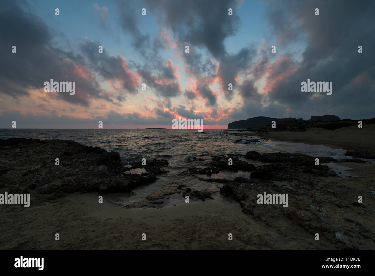 Pink and blue sunset on the beach in Creta, Greece. Beach with blacks ...