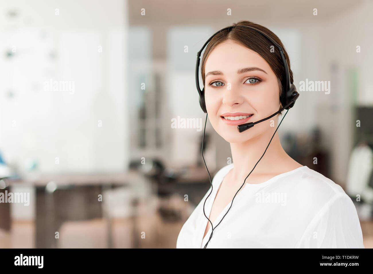 Young friendly technical support agent talking to the client with a ...