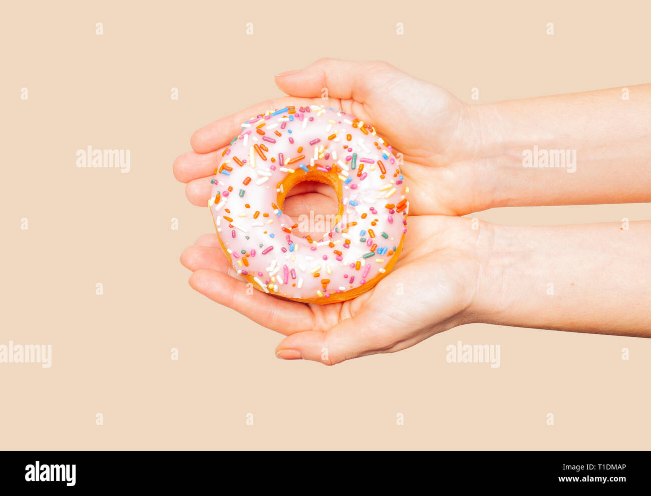 Female hands holding donut. Colorful donut on pastel background Stock ...