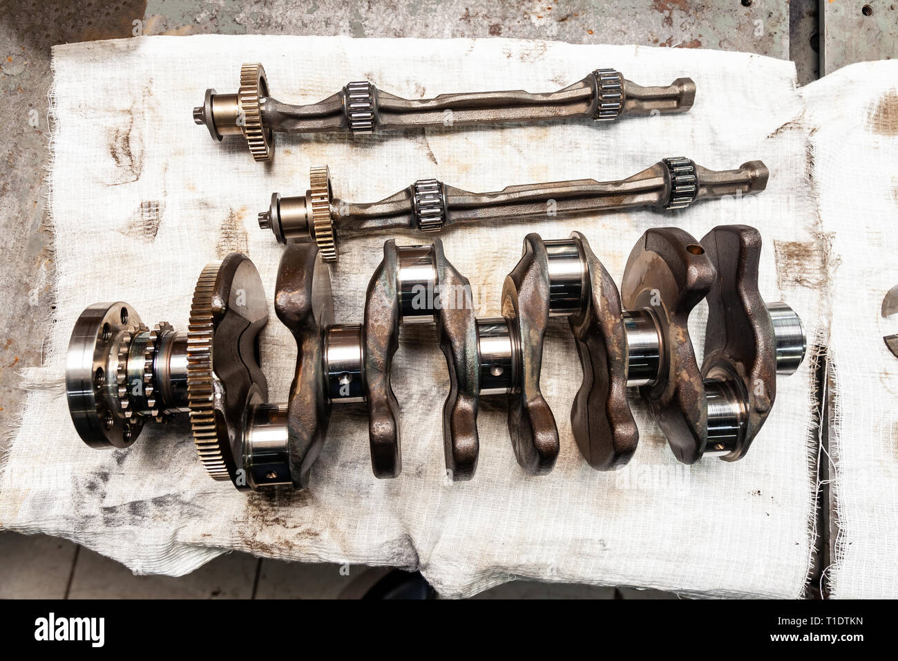Close-up of a car crankshaft removed for replacement on a workbench in ...
