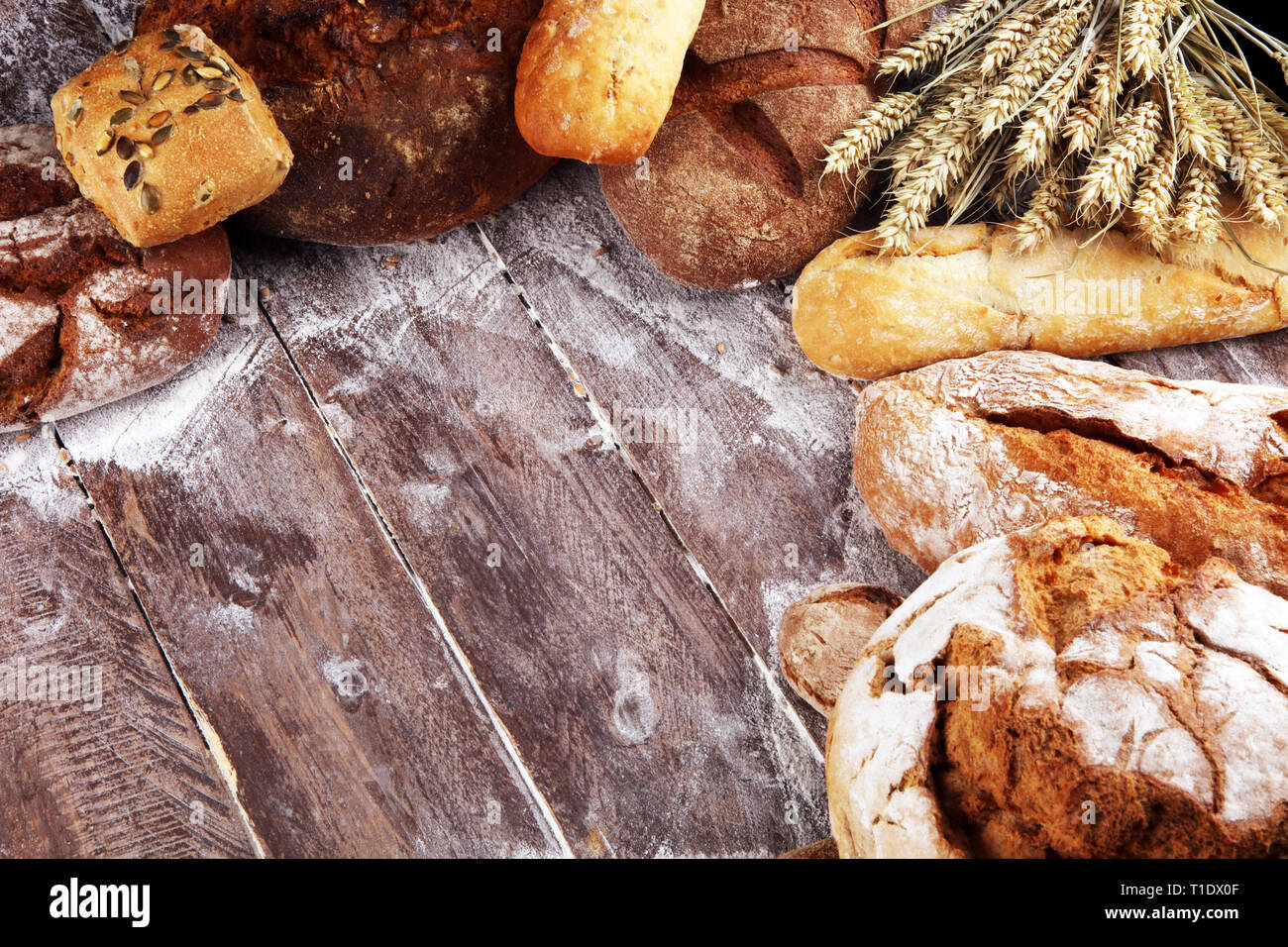 Different kinds of bread and bread rolls on board from above. Kitchen ...