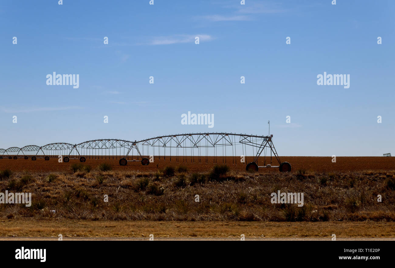 Pivot irrigation system sprinkler watering crops at farm land in the ...