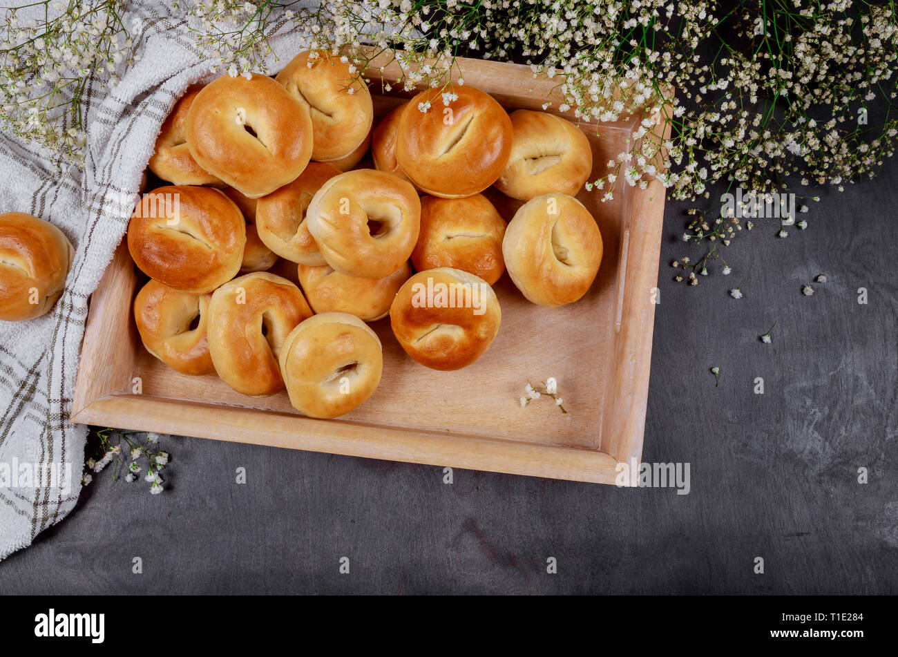 Delicious homemade golden buns in tray, vintage wooden rustic table ...