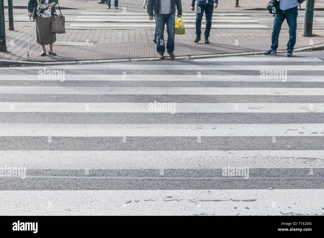 Pedestrians waiting to cross on the road, feet rushing through the ...