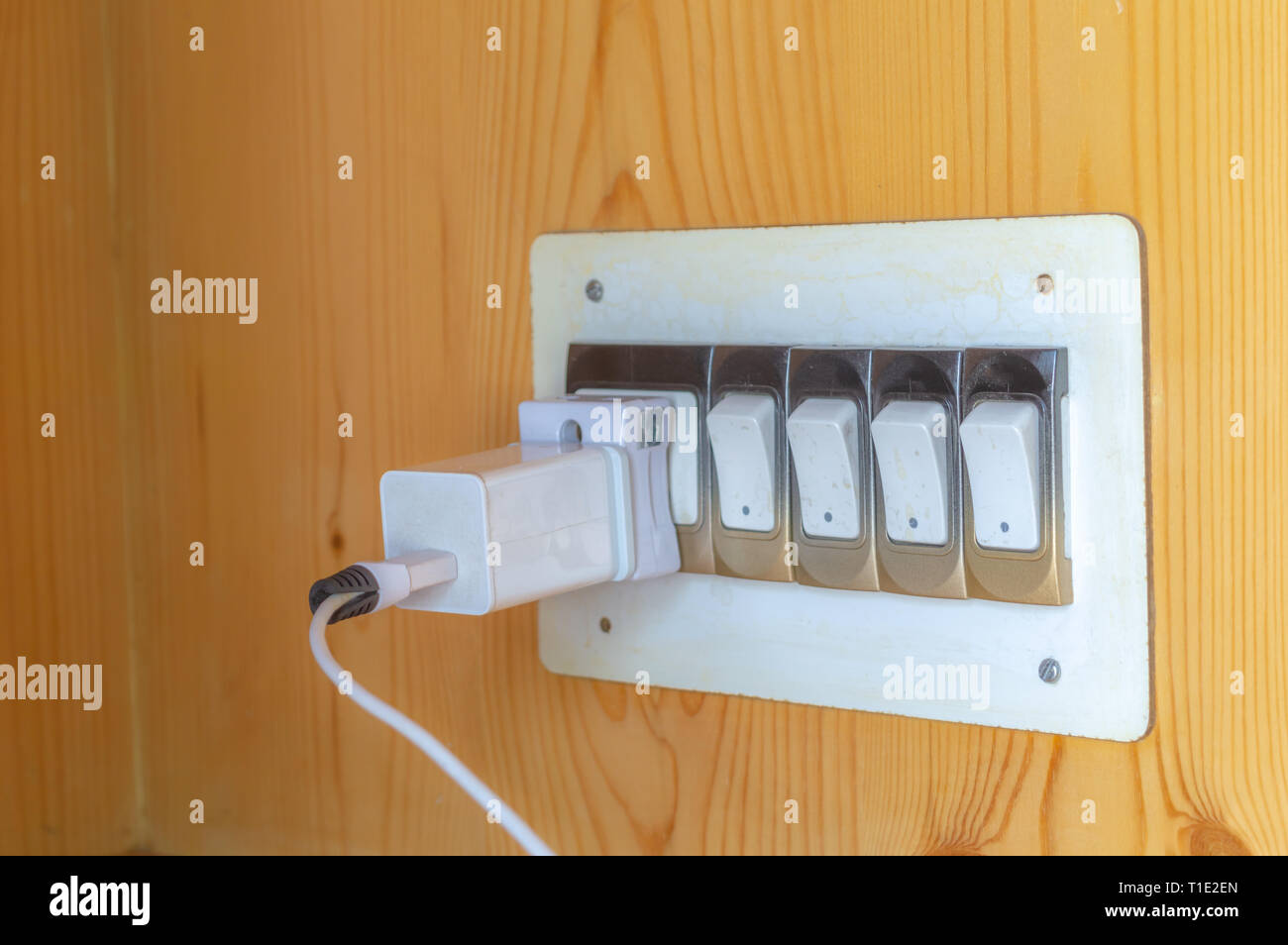 An Indian pin USB charger inserted into a wall socket with switches ...