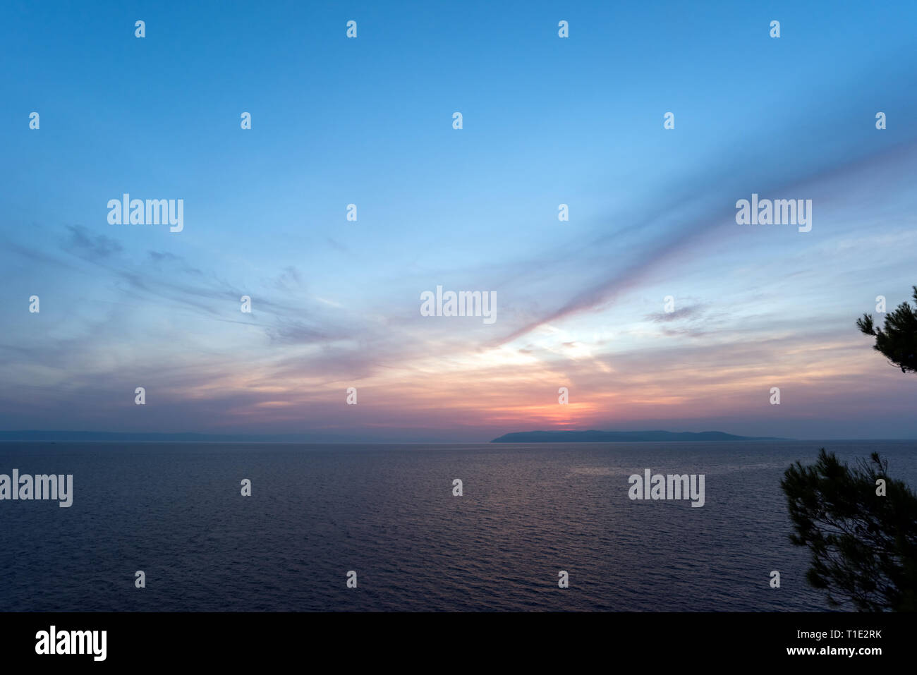Sunset over the sea with mysterious sky with reflection in the water ...